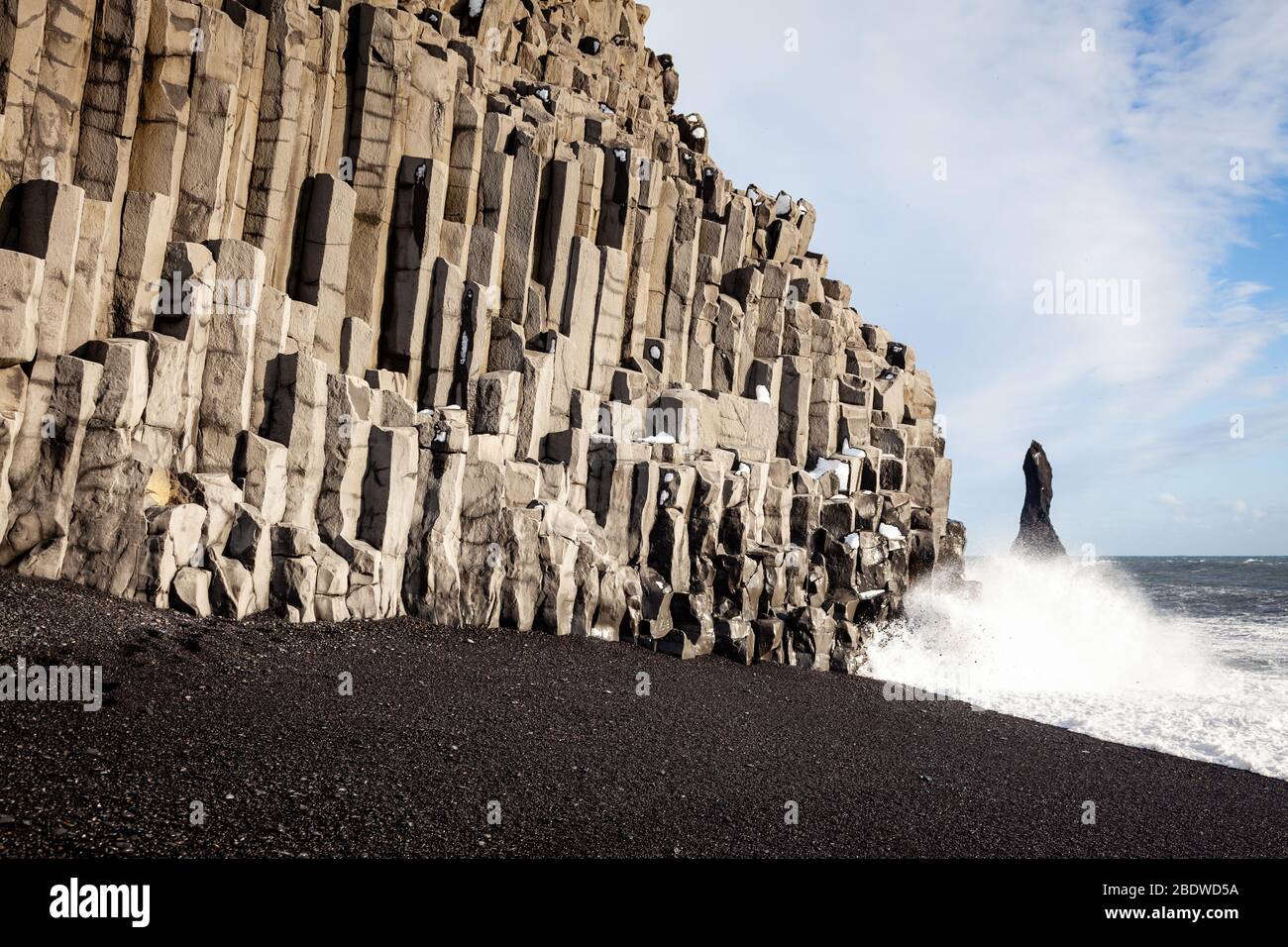 Reynisdrangar sea stacks and basalt columns at Reynisfjara black sand beach in winter near Vík í ...