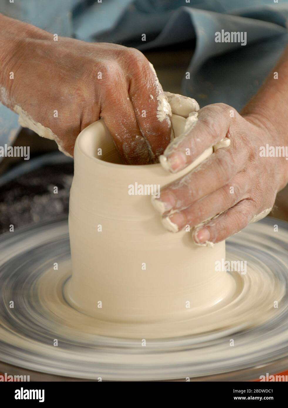 The ceramist creates a pottery (ceramic ware). The photo contains only ...