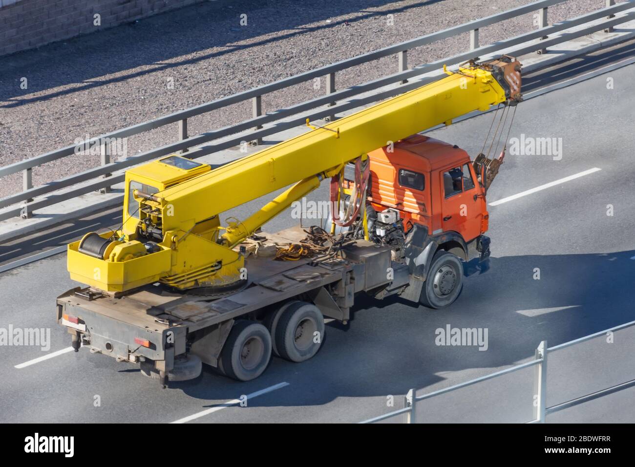 Mobile yellow big crane truck rides on the highway Stock Photo - Alamy