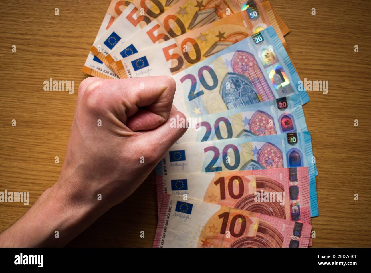 Woman tight fist and paper money banknotes on wooden background Stock ...