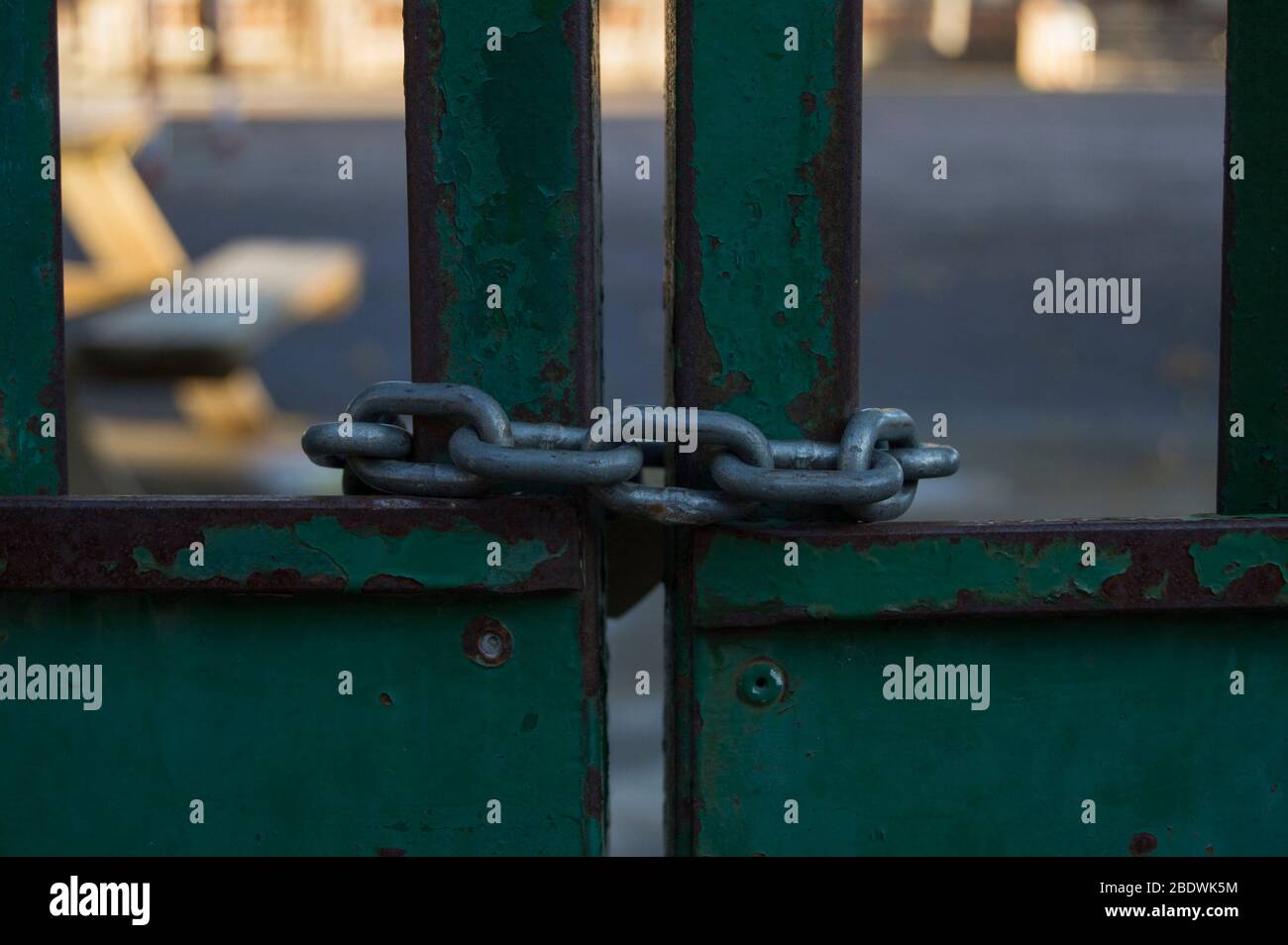Iron chain closing a rusty metal door painted green Stock Photo - Alamy