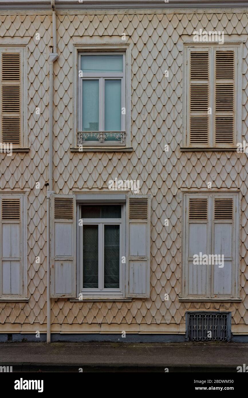 The decorative cream painted shingles on the front of a traditional ...