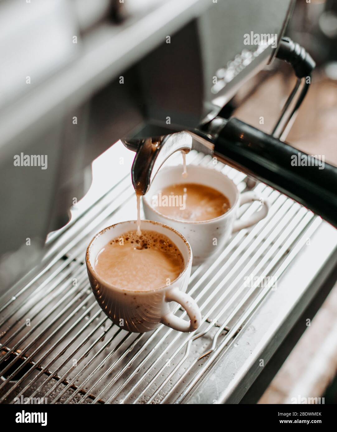 two espresso cups under coffee engine Stock Photo - Alamy