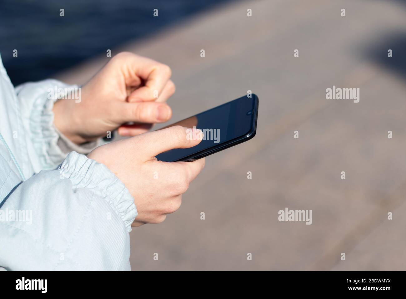 Female hands holding phone close-up on street with copy space Stock ...