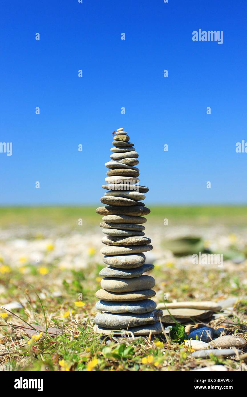 Rock balancing, stone stacks on the beach, blue sky in background Stock ...