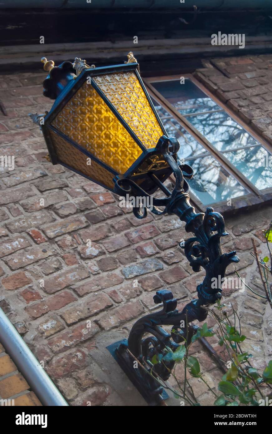 A decorative street light mounted on a brick wall in Rostock, Germany ...