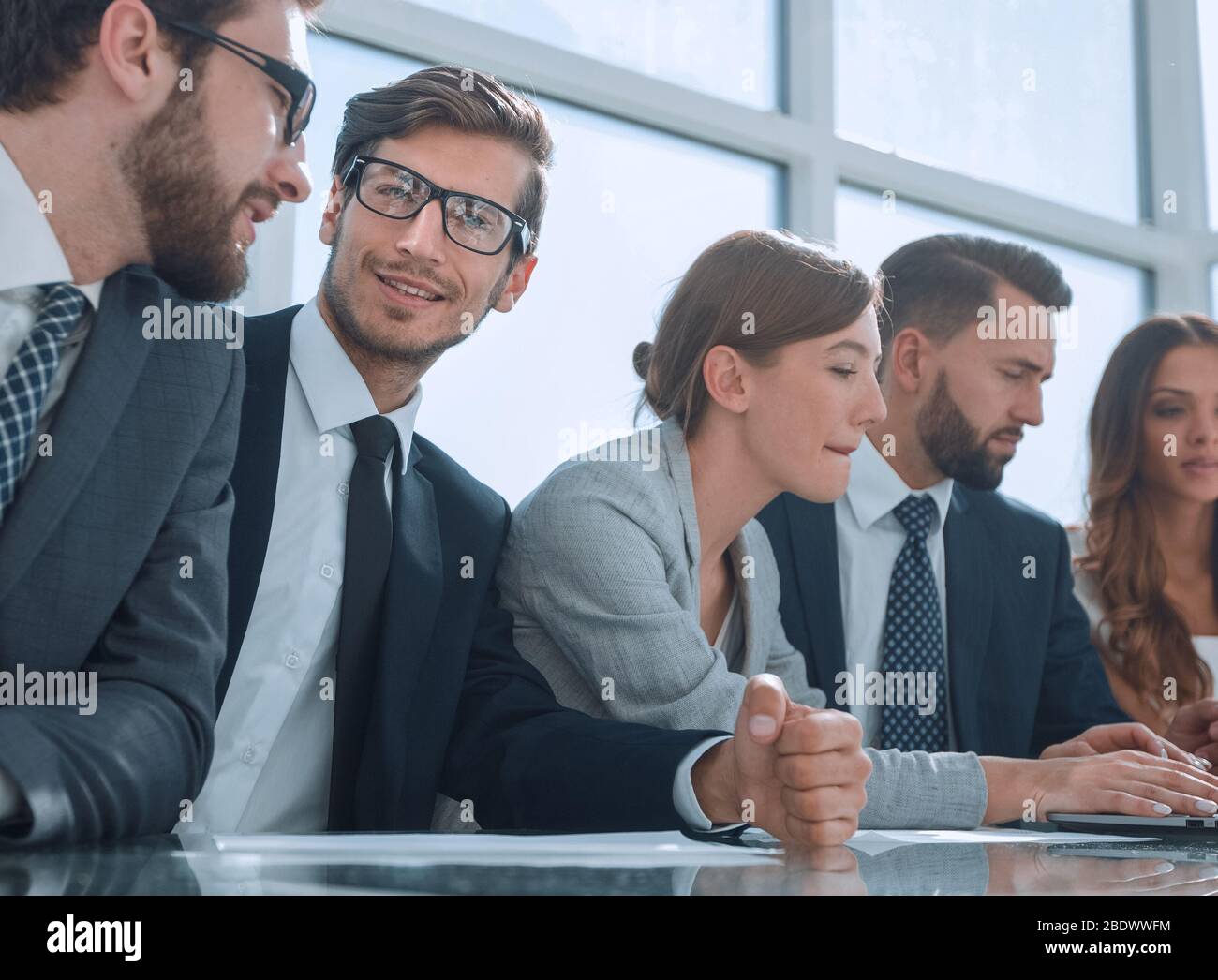 business team sitting at the office Desk in the office Stock Photo - Alamy