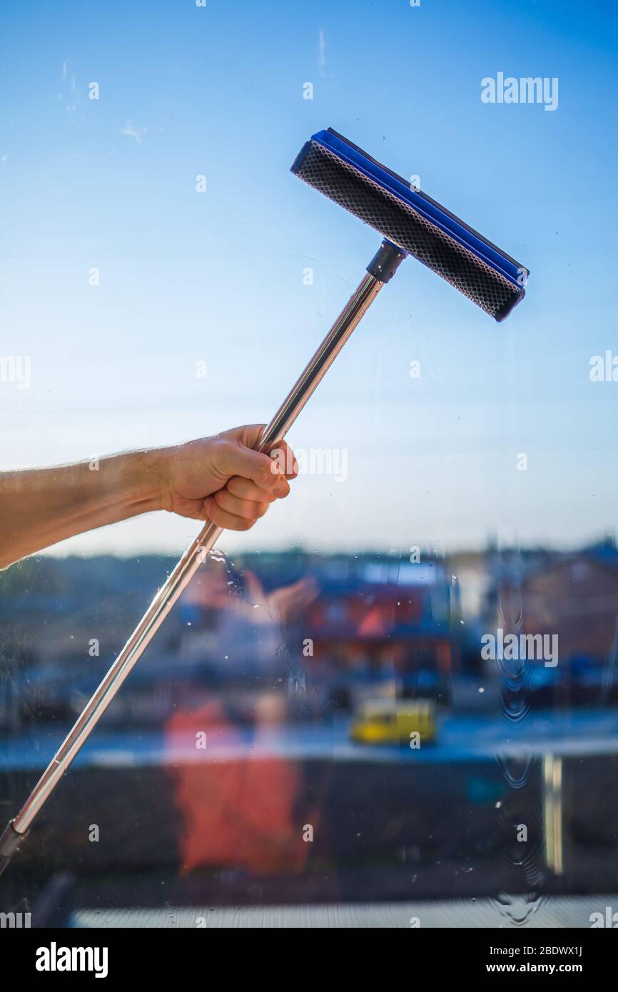 Window cleaning in high-rise buildings, houses with a brush. Window ...