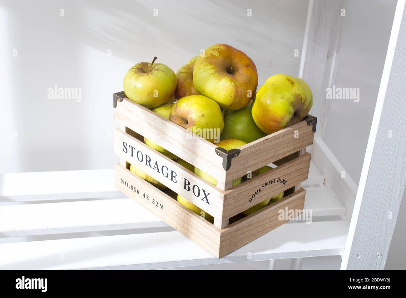 The green apples in the wooden box at the shelf. Concept Stock Photo ...
