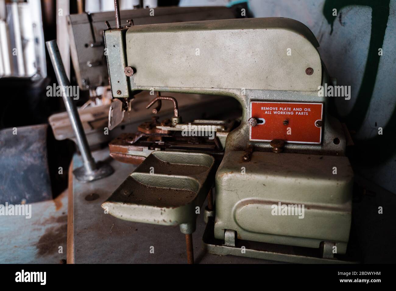Closeup photo of old sewing machine and item of clothing, vintage retro ...