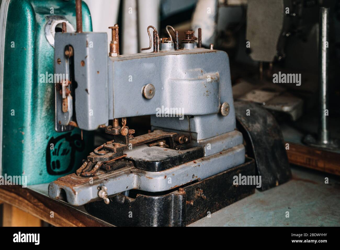 Closeup photo of old sewing machine and item of clothing, vintage retro ...