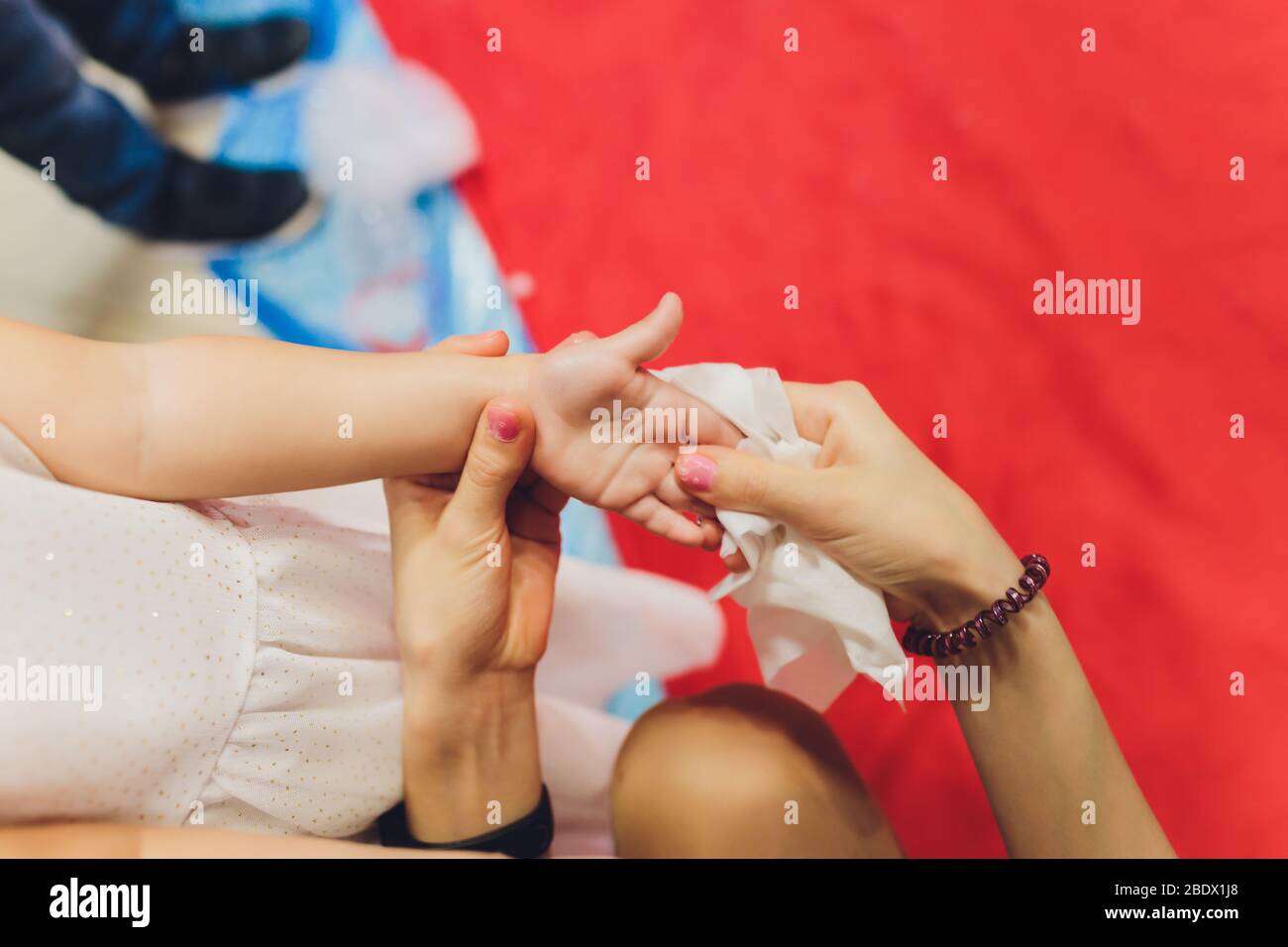 Mom wipes her daughter s palm with a damp napkin. Mom cares for her ...