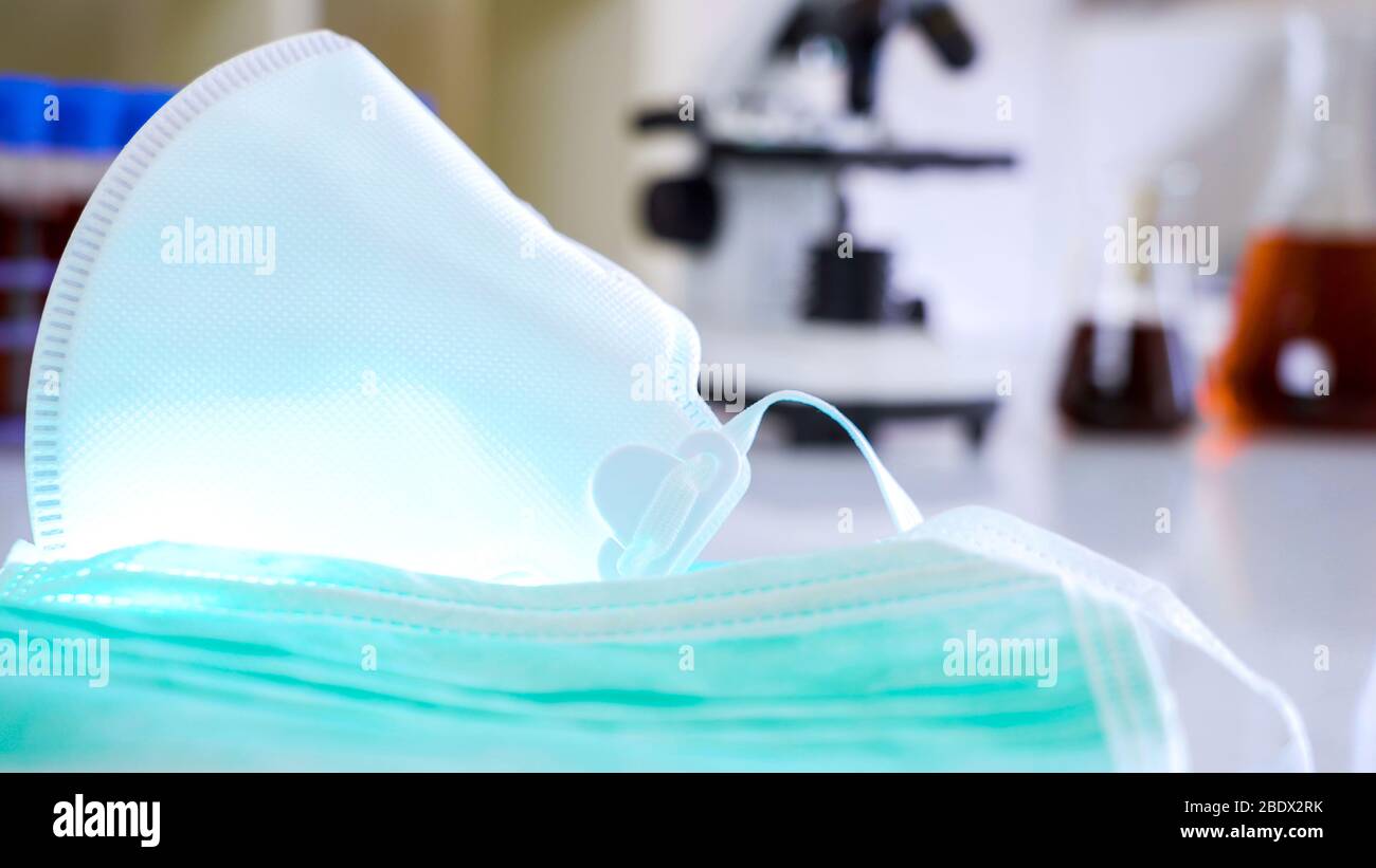 A white face mask on top of the surgical mask inside the laboratory ...