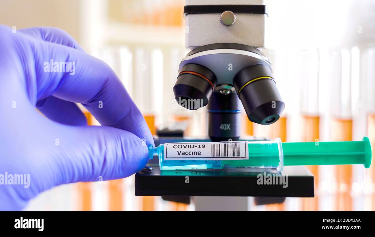 A syringe with COVID-19 coronavirus vaccine inside being put on the ...