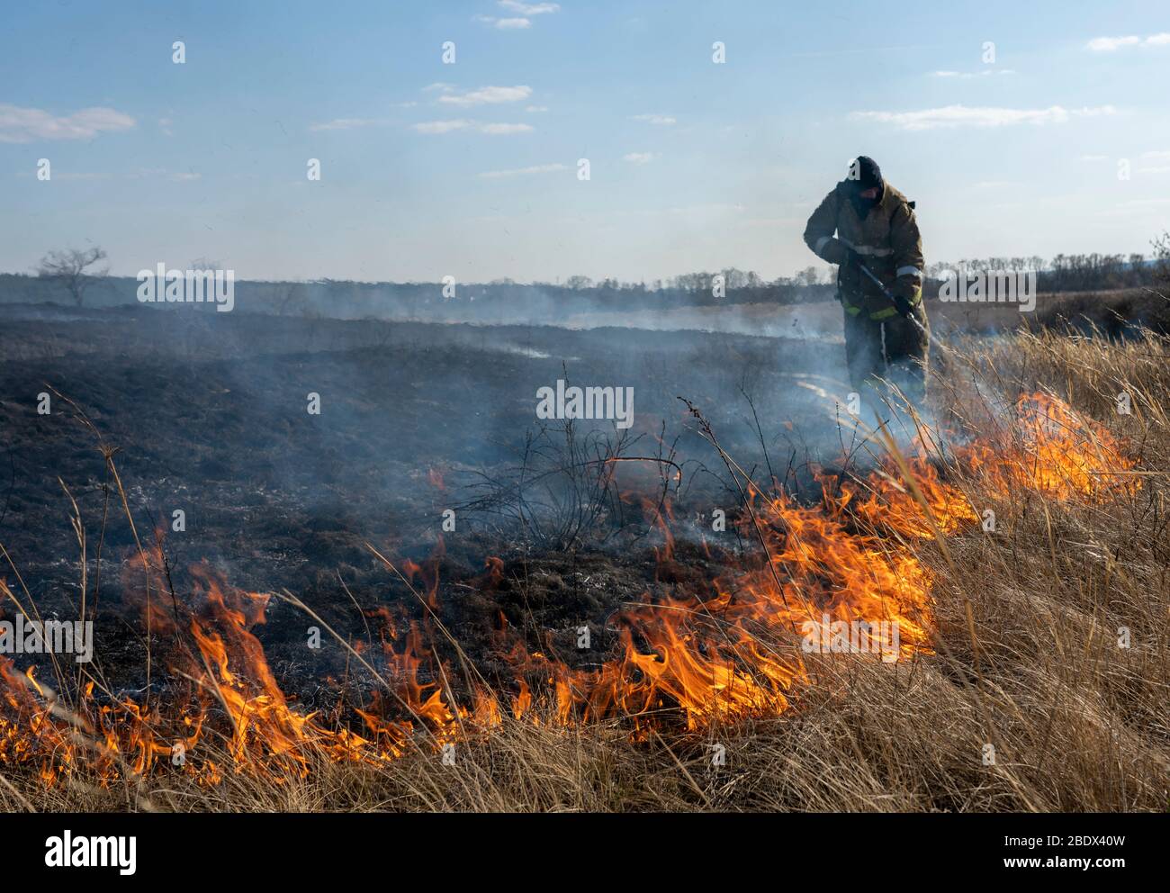firefighters extinguish the flames of burning grass Stock Photo - Alamy