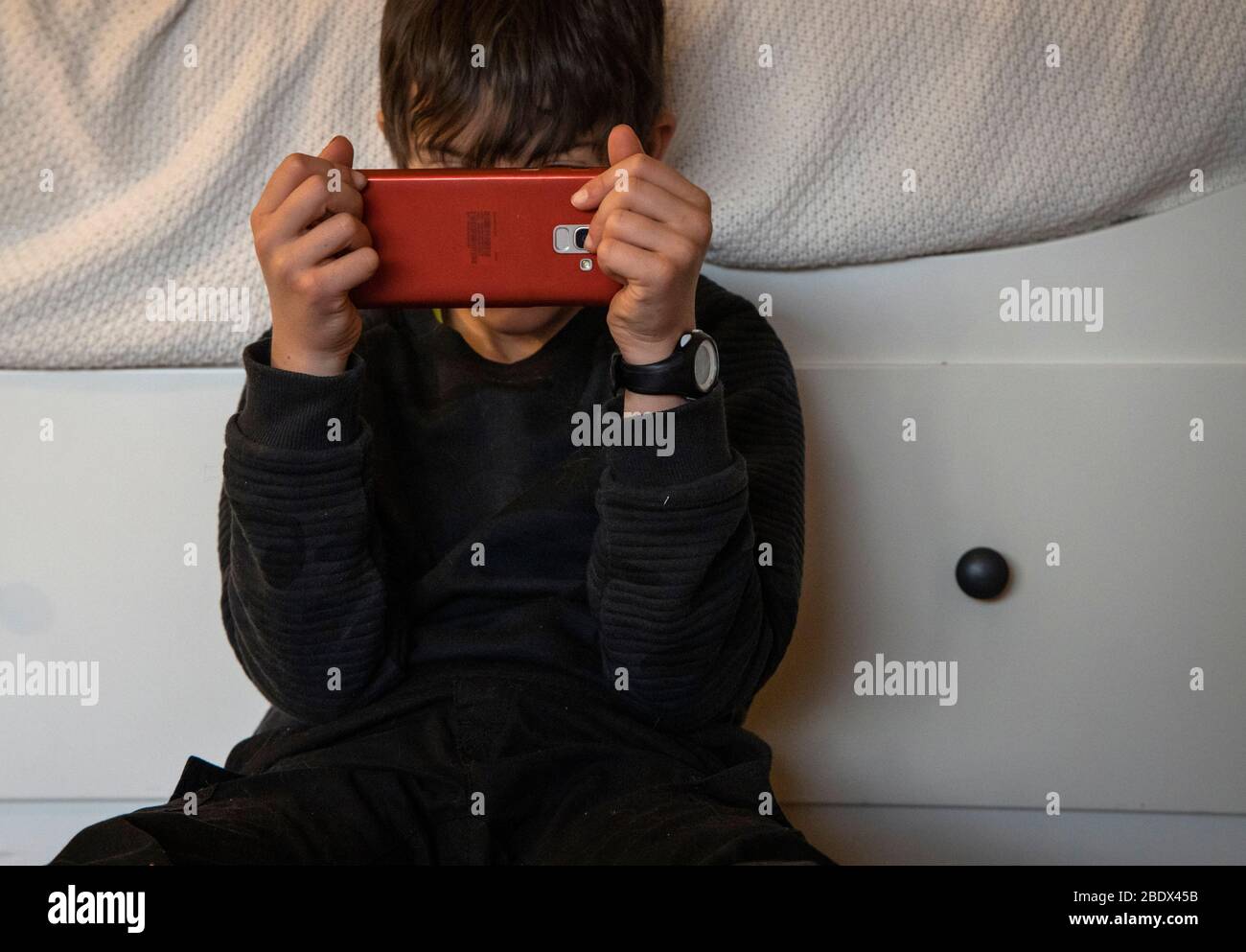 Boy using his parents mobile phone during Covid19 confinement in ...