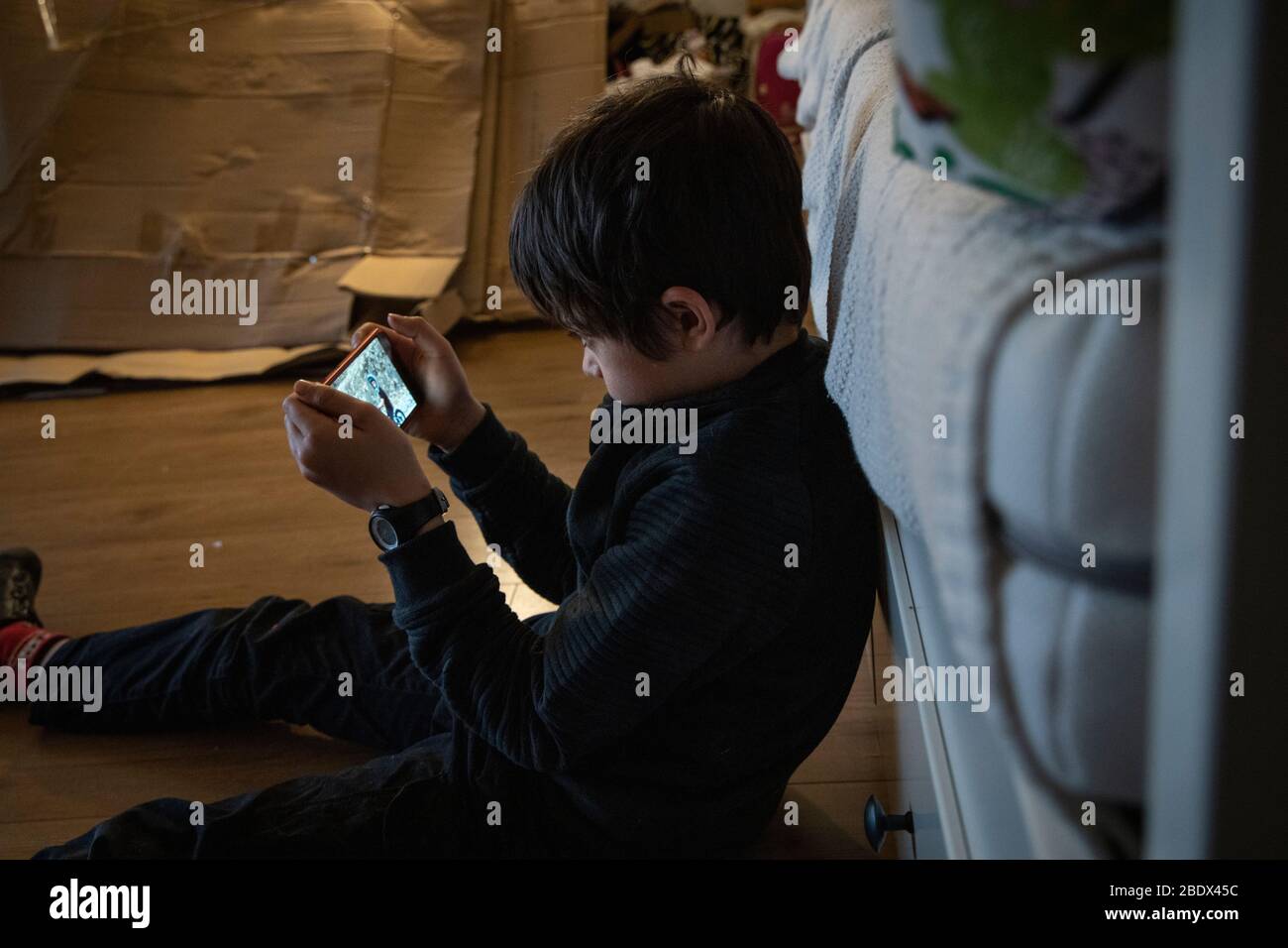Boy using his parents mobile phone during Covid19 confinement in ...