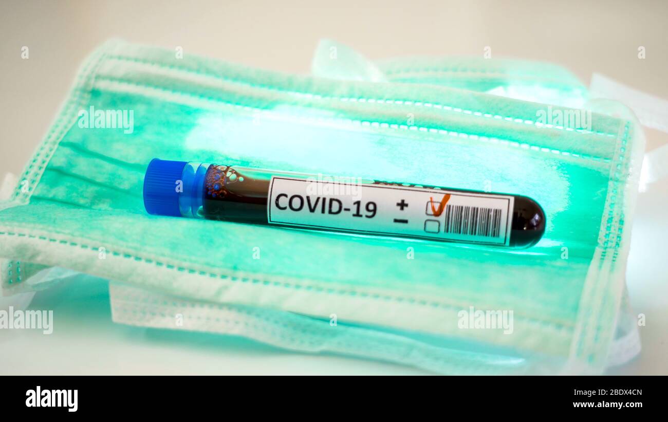 The surgical mask with the Coronavirus positive test kit on top of the ...