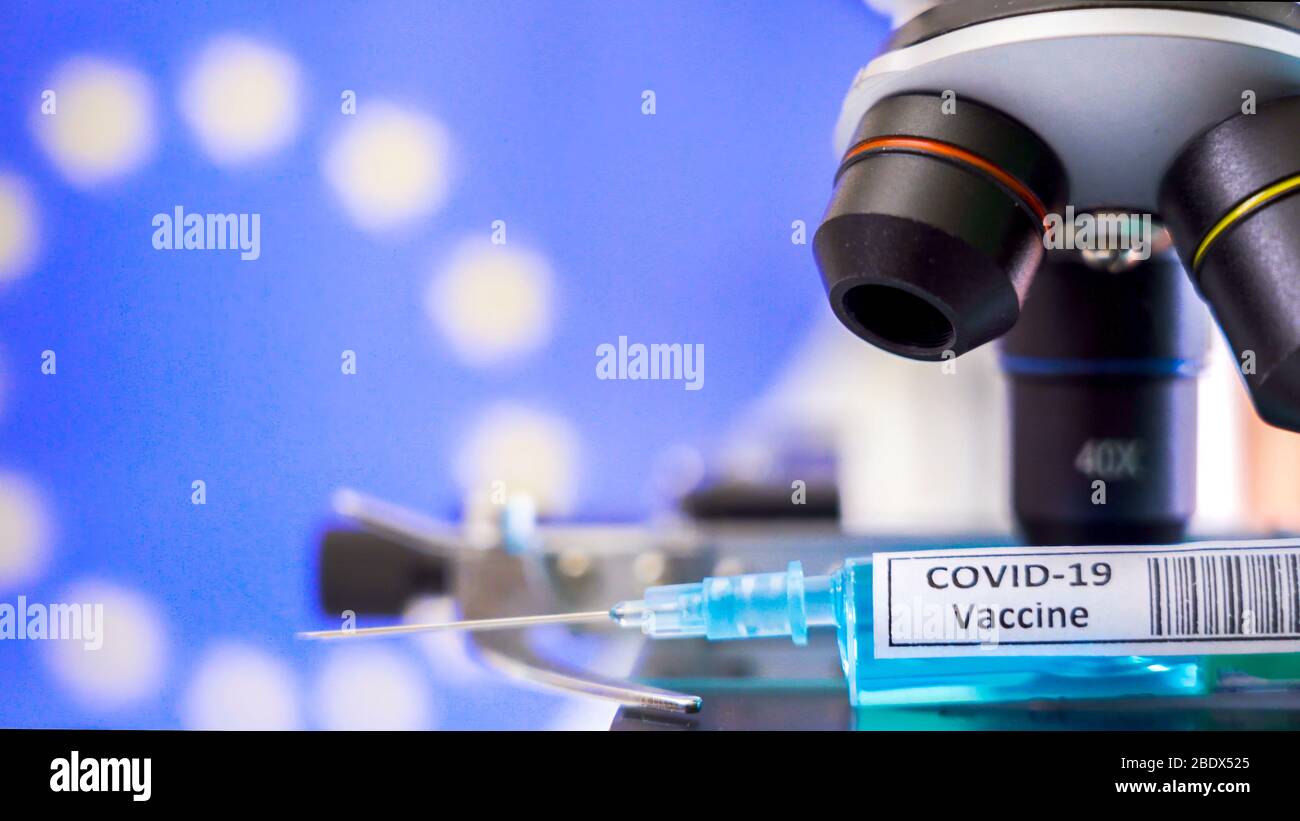 The objective lens of the microscope and the syringe for Covid-19 ...