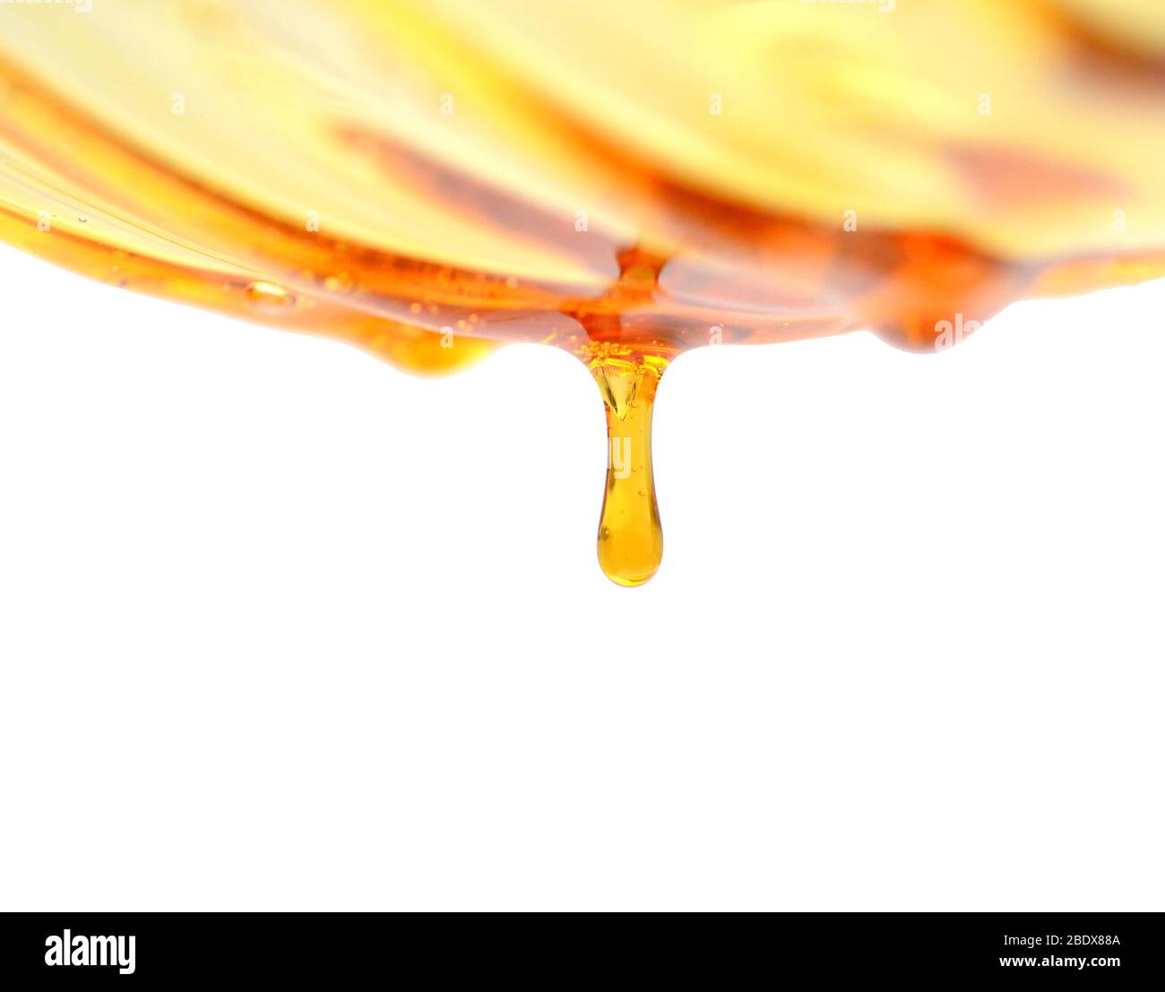 A stream of golden honey and a pool on a white background Stock Photo ...