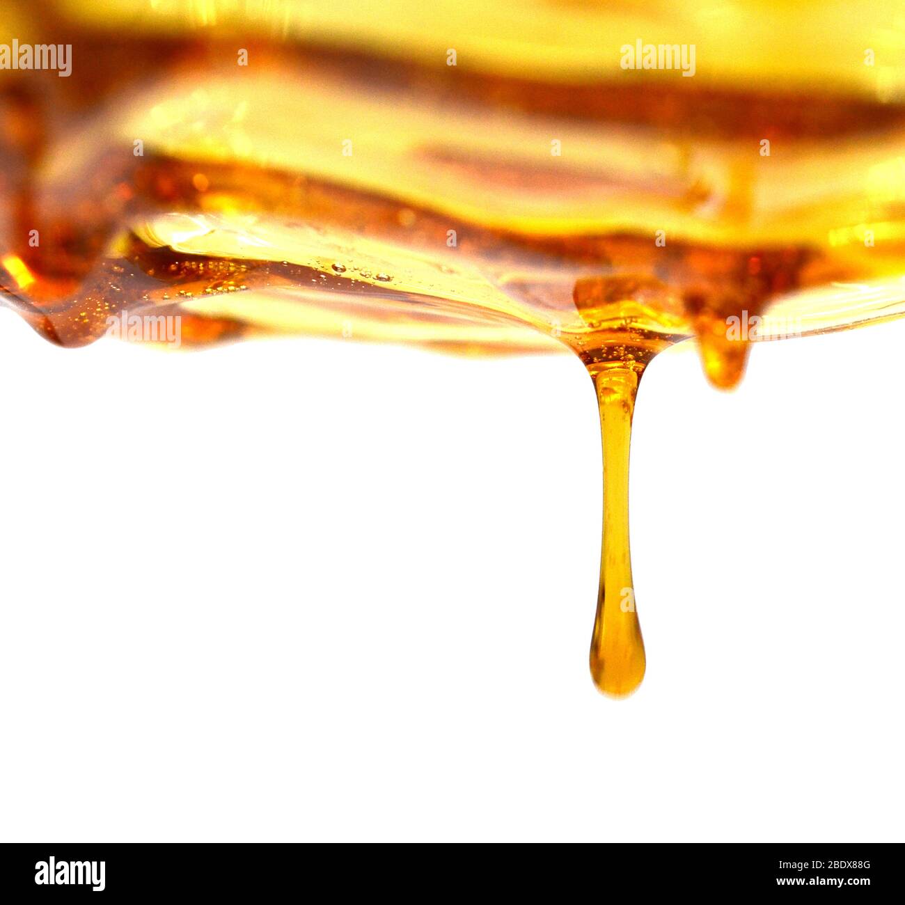 A stream of golden honey and a pool on a white background Stock Photo ...
