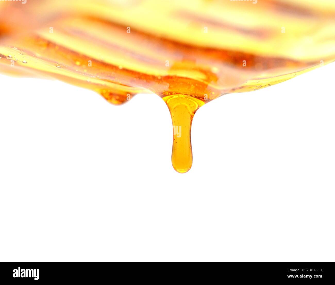 A stream of golden honey and a pool on a white background Stock Photo ...