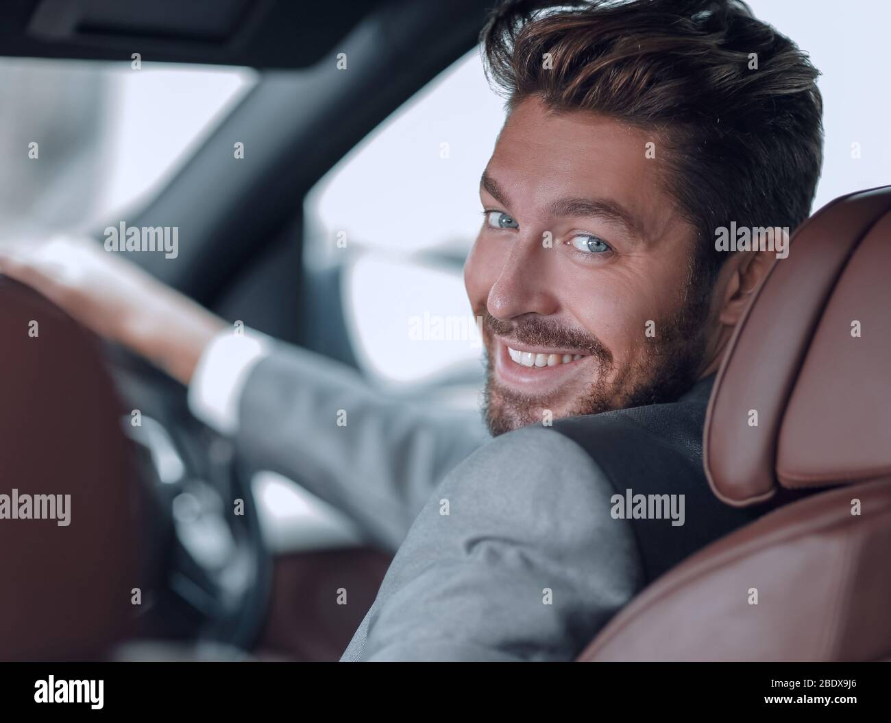 rear view, young man driving his car, looking at camera Stock Photo - Alamy