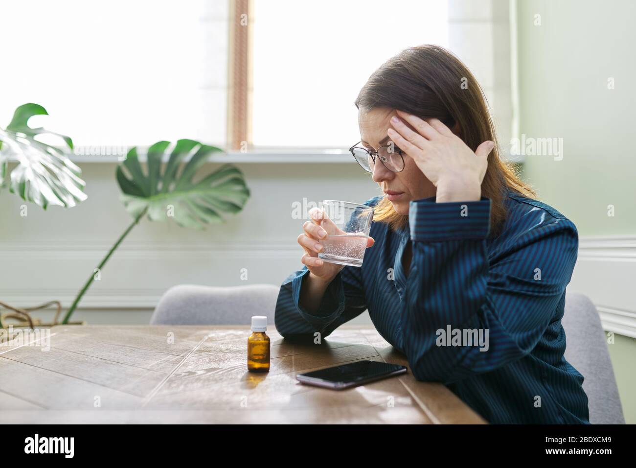 Mature Woman Dripping Drops With Glass Of Water Drinking Sedative