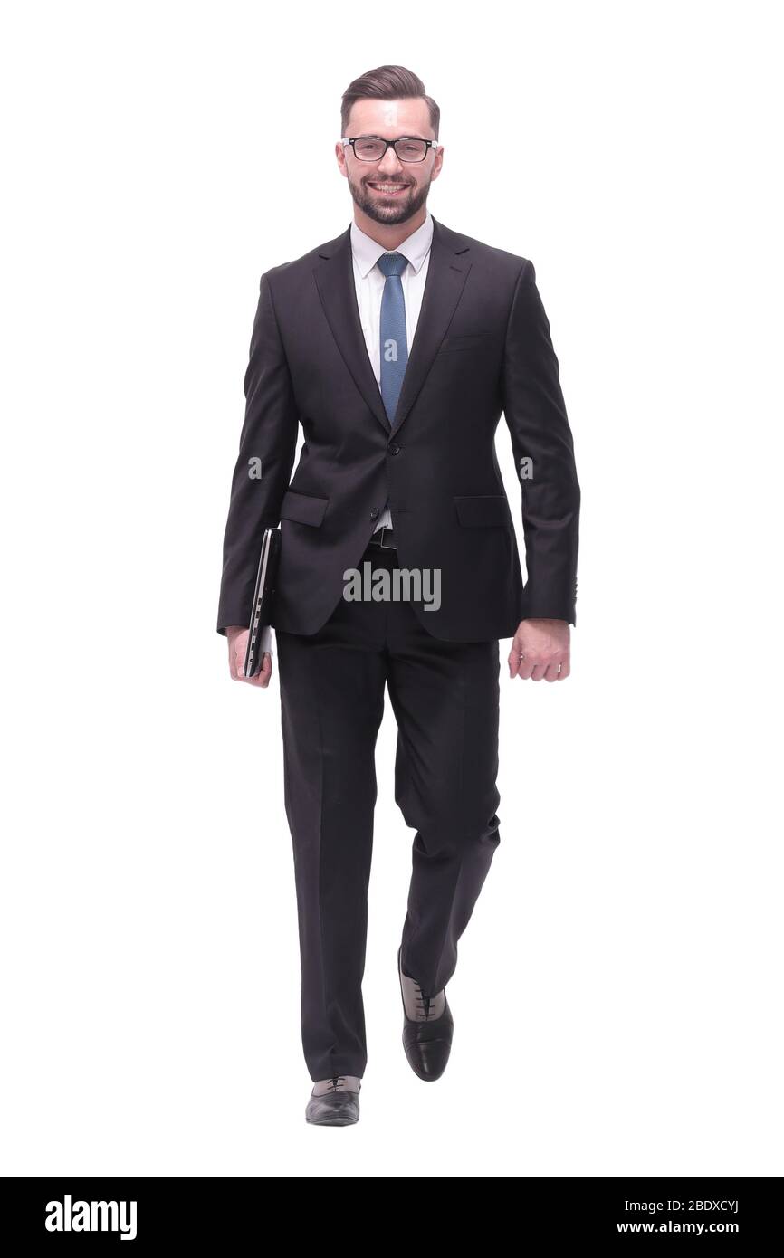 in full growth. successful businessman with laptop stepping forward ...