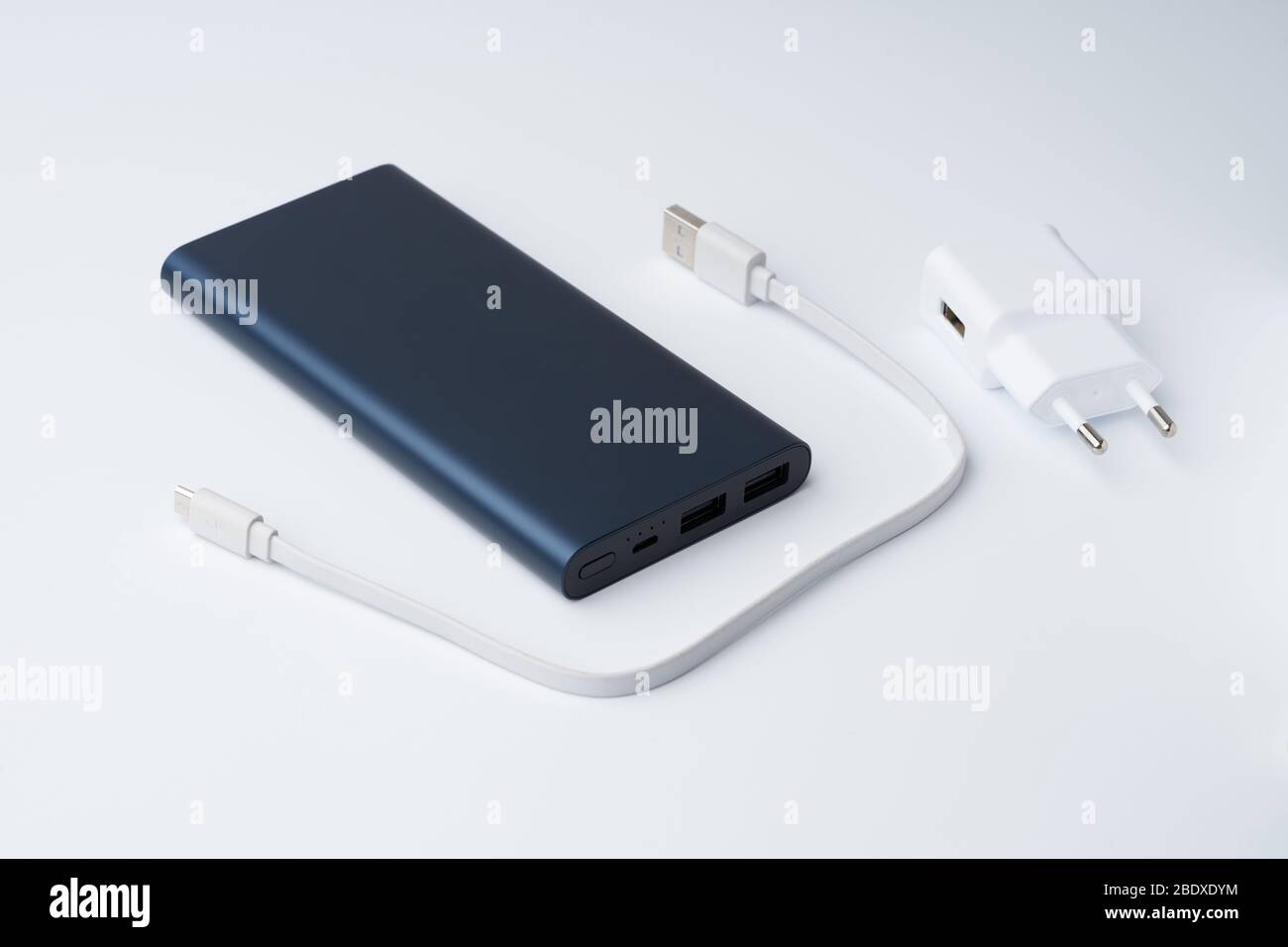 Disconnected white USB power adapter, cable and blue power bank for ...