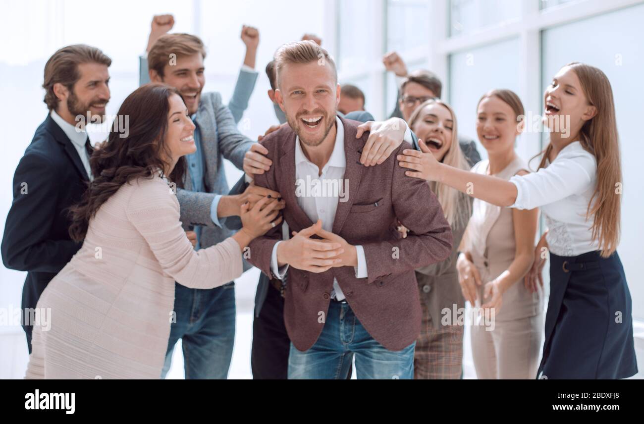 happy team of employees congratulating their colleague Stock Photo - Alamy