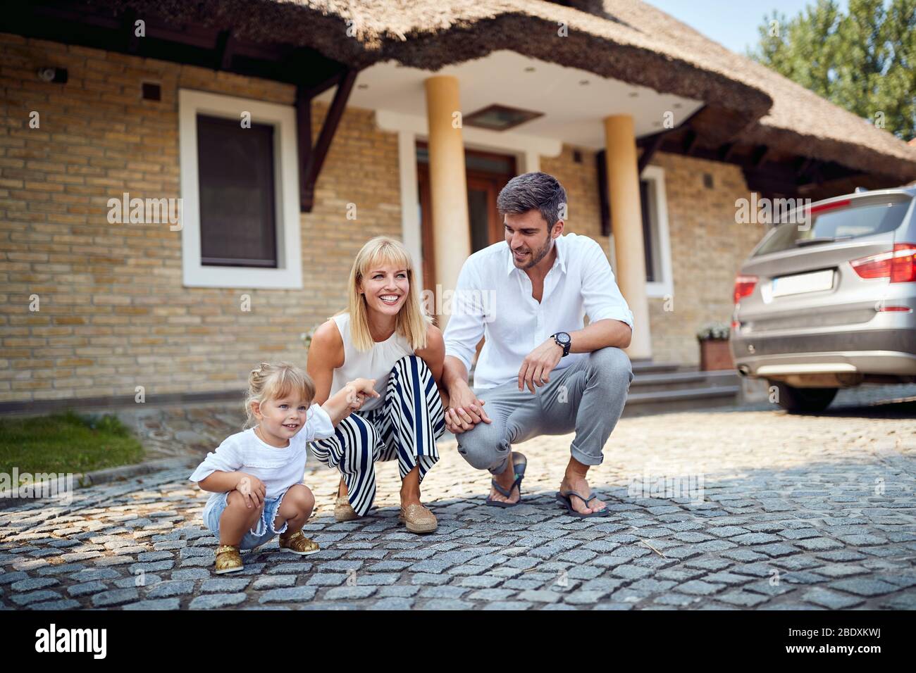 Young family with cute daughter in crouch Stock Photo - Alamy
