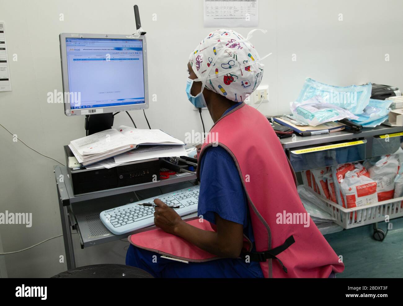 An NHS Nurse records notes on a patient during surgery in an NHS ...