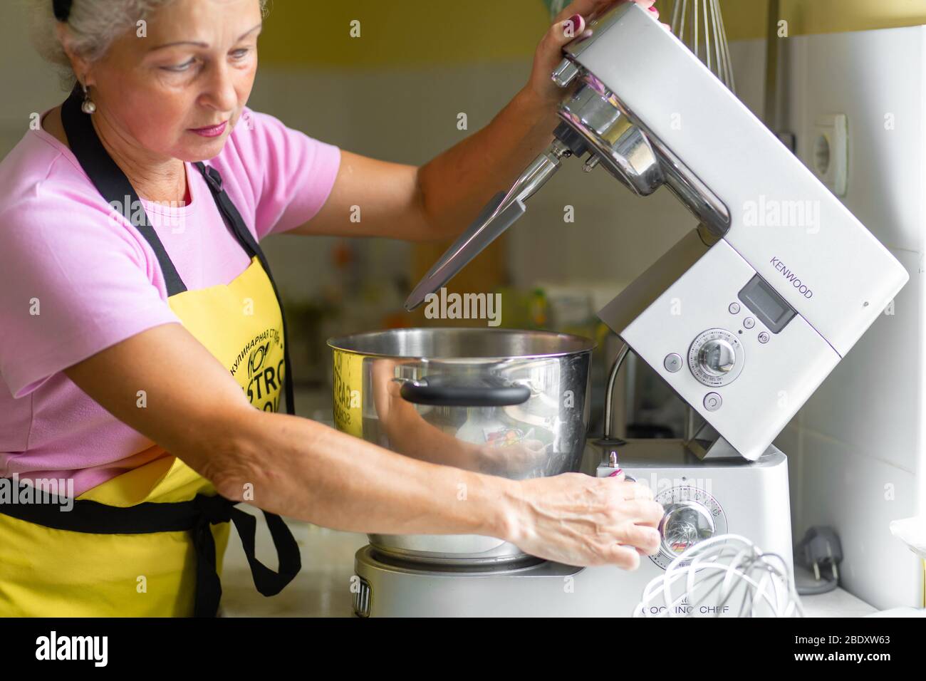 Woman professional pastry chef preparing a dessert. Adds ingredients ...