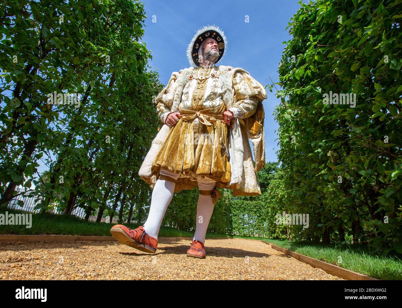 An Actor, dressed as King Henry the Eighth, strolls down a path in the ...