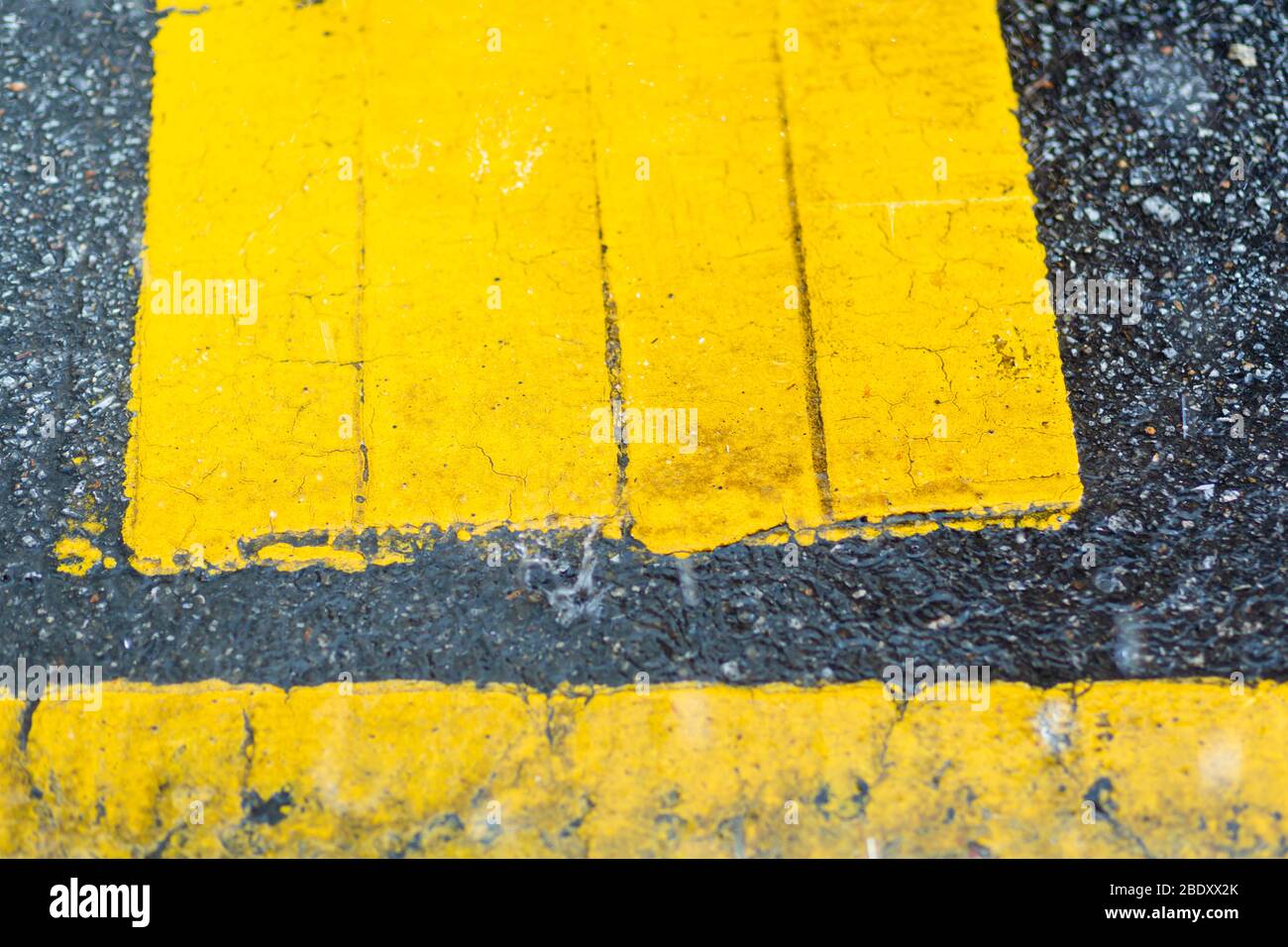 Road markings in yellow paint on black asphalt Stock Photo - Alamy