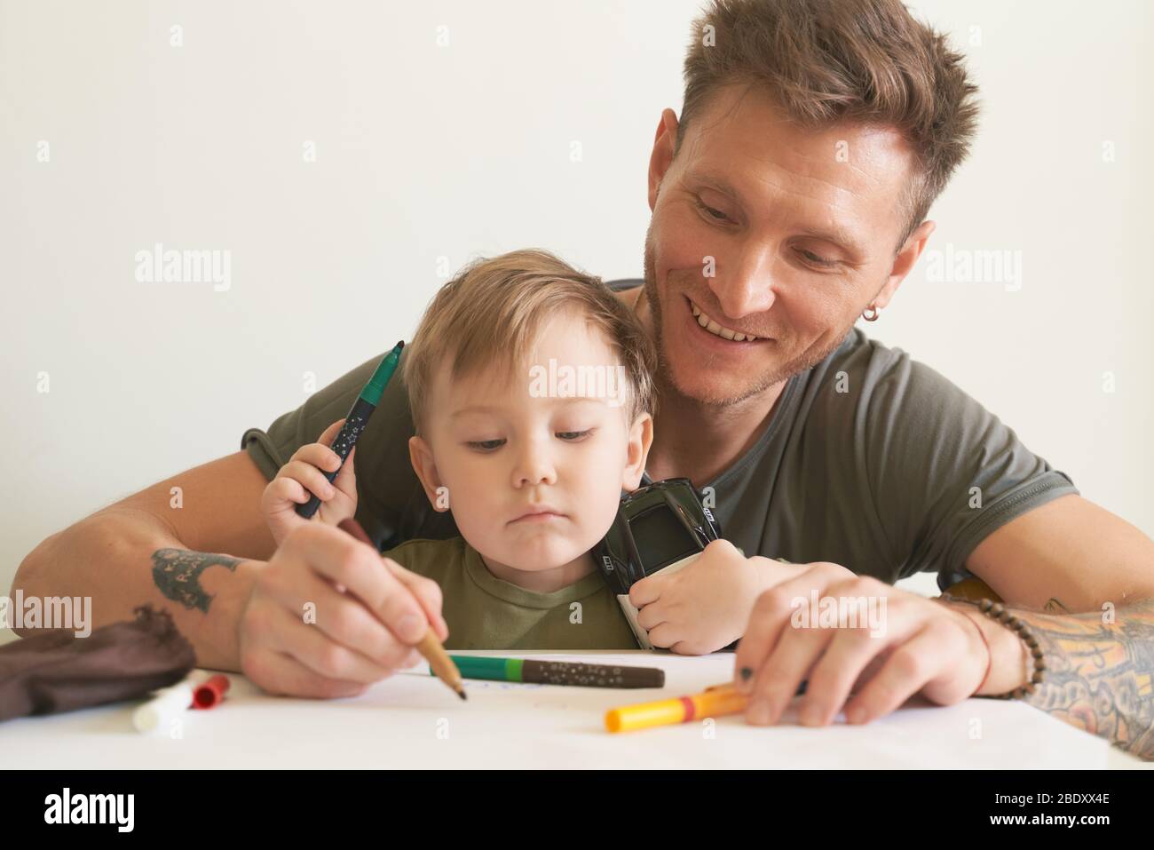 Young father helps son at age of two draw, teaches Stock Photo - Alamy