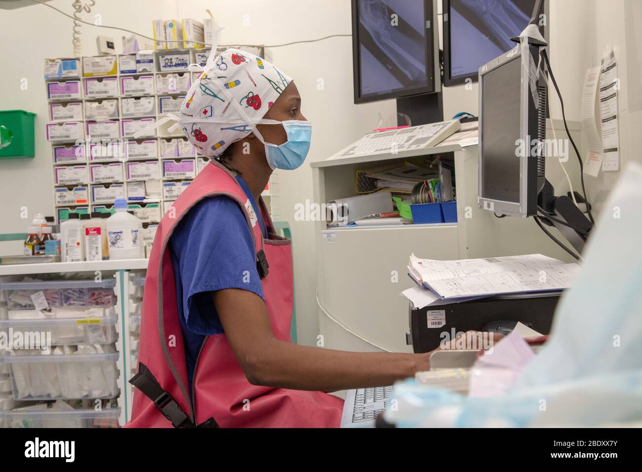 An NHS Nurse records notes on a patient during surgery in an NHS ...