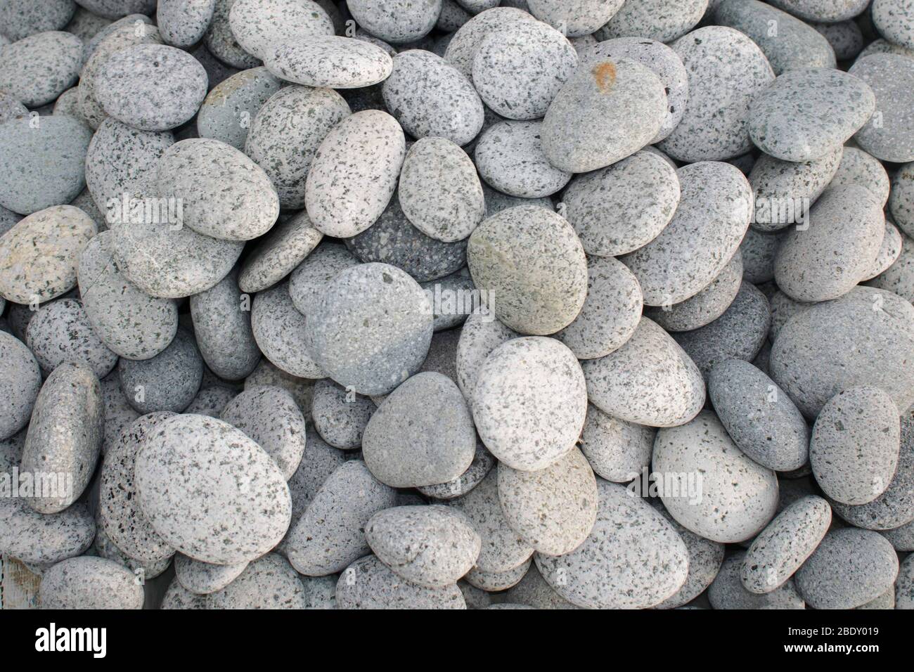 Dotted smooth and flat pebble stones on a pile Stock Photo - Alamy