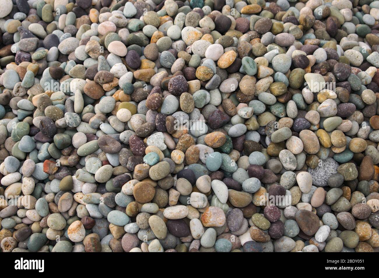 A huge pile of colourful pebble stones or cobble stones. Beach stones ...