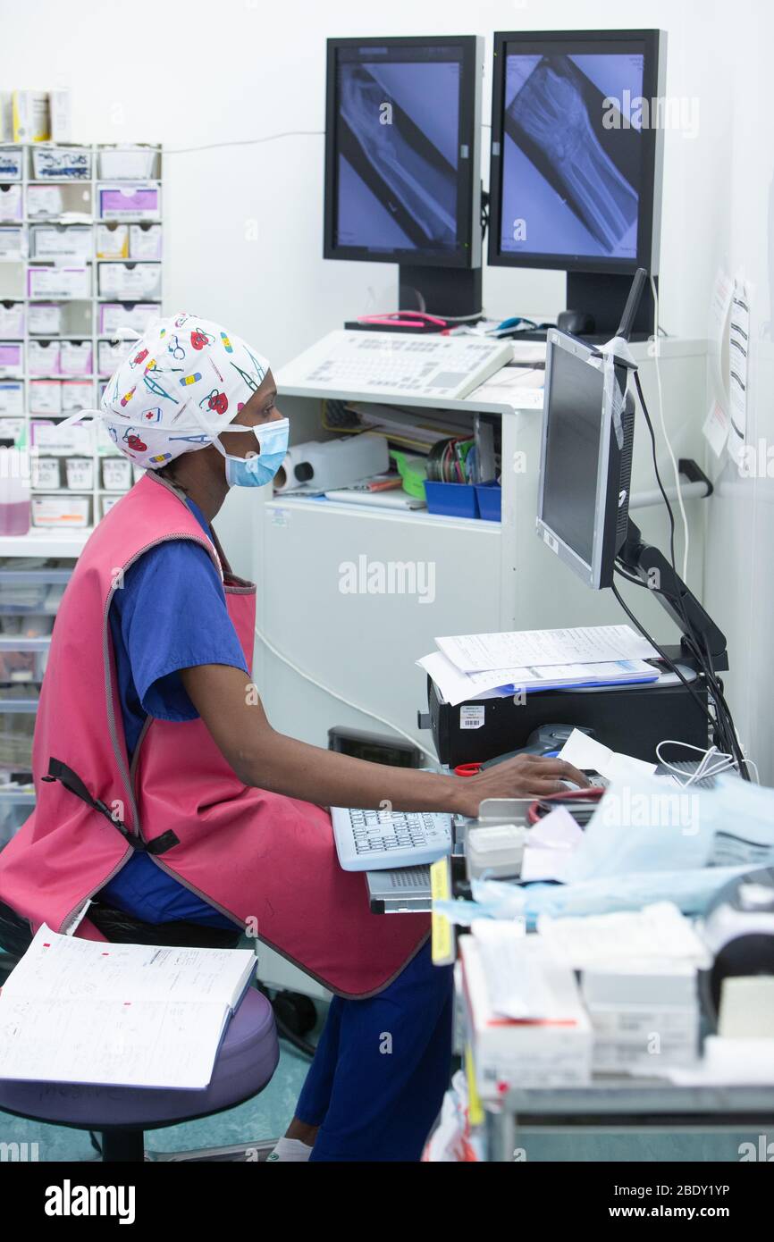 An NHS Nurse records notes on a patient during surgery in an NHS ...