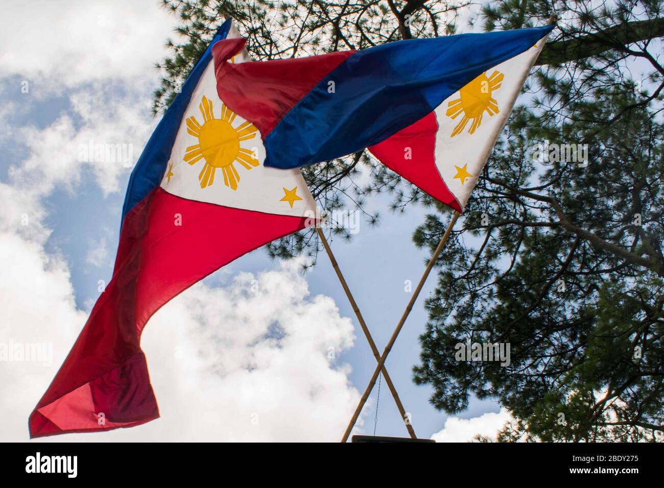 Wind blowing to a two criss crossed Philippine Flag Stock Photo - Alamy