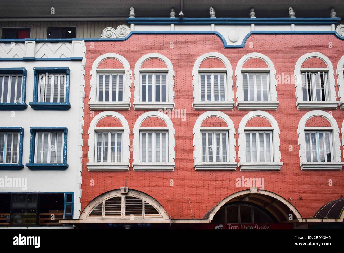 Brick house with white painted windows and flower pots hanging at the ...