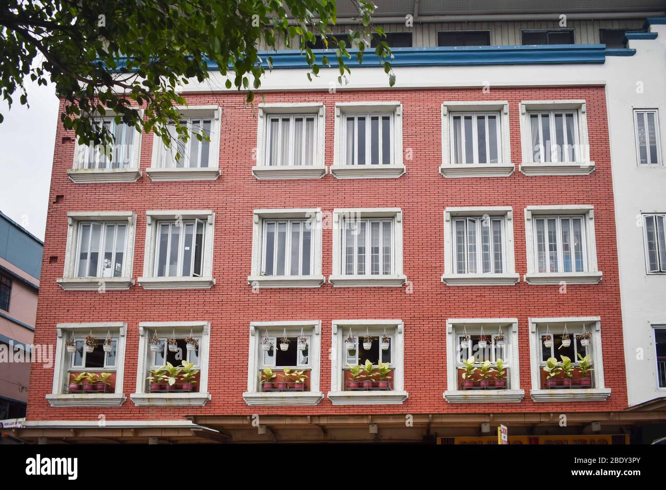 Brick house with white painted windows and flower pots hanging at the ...