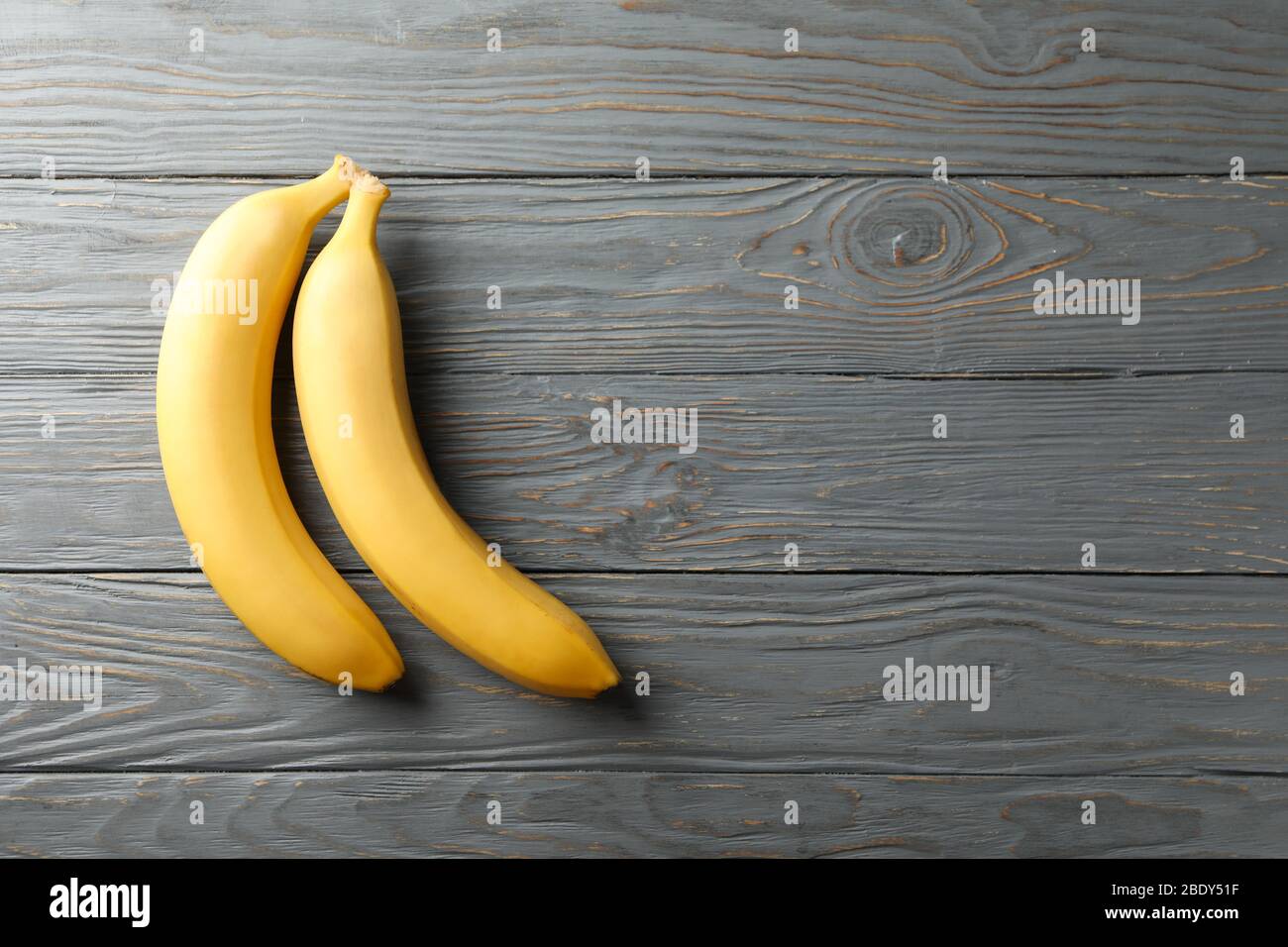 Bananas on gray wooden background. Fresh fruit Stock Photo - Alamy