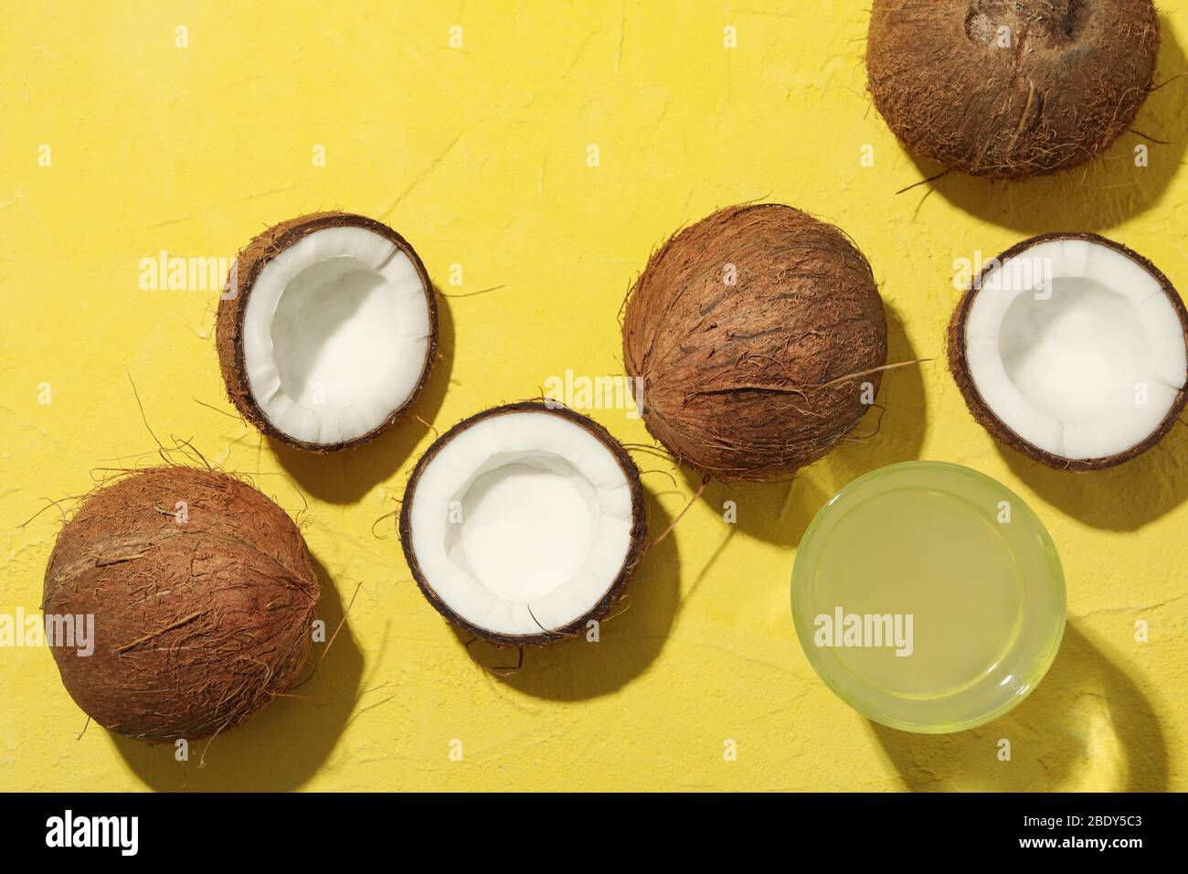 Coconut and water on yellow background, top view. Tropical fruit Stock ...