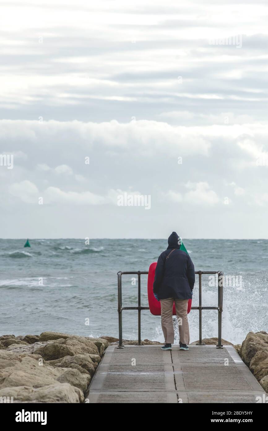 Man stand on the jetty at beach Stock Photo - Alamy