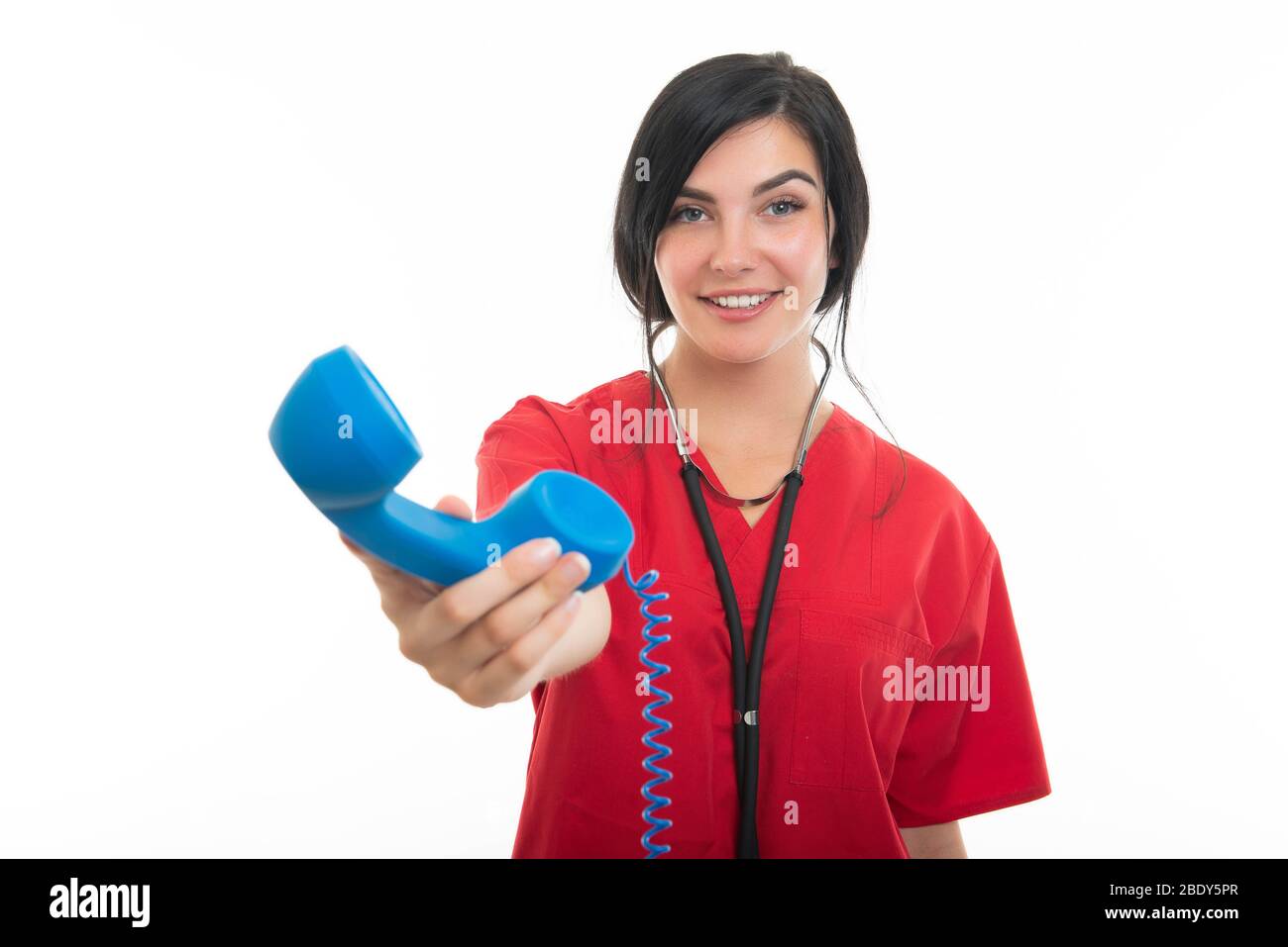 Portrait of young attractive female nurse handing telephone receiver ...
