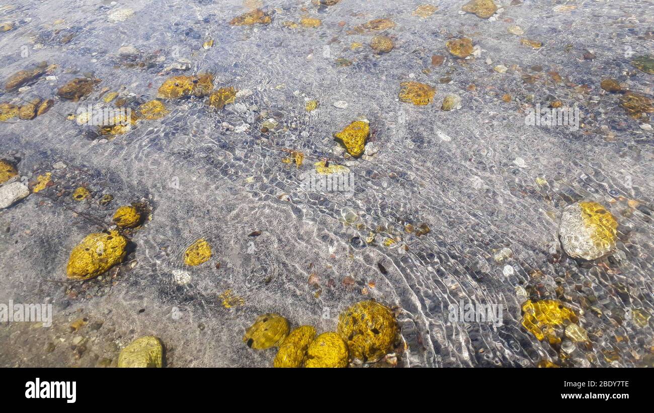 Crystal clear river water with orange rocks underneath Stock Photo - Alamy