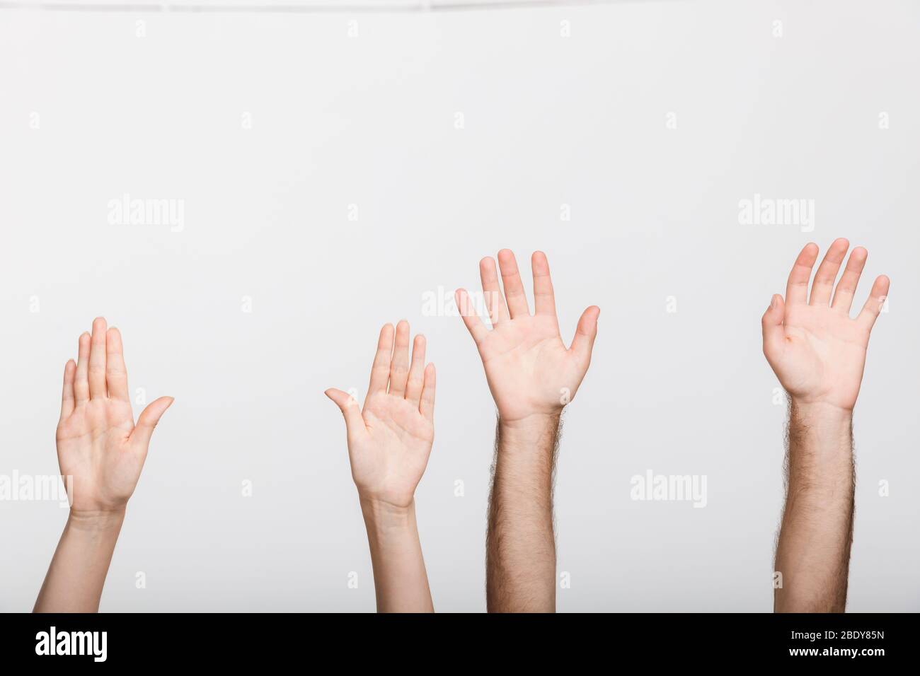 Closeup image of a man's and woman's raised hands isolated over white ...